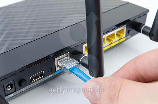 Man plugs internet cable into the router (686793846) - 게티이미지뱅크