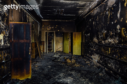 Burned by fire interior of old hospital. Charred walls and doors of ...