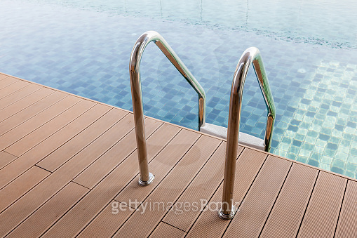 Grab bars ladder entrance to the clear blue swimming pool. (669526648 ...