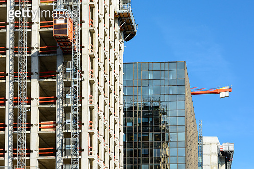 Glass building between two concrete buildings under construction with a ...