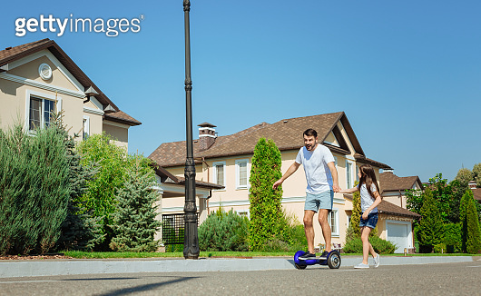 Little girl following father riding self-balancing scooter 이미지 ...