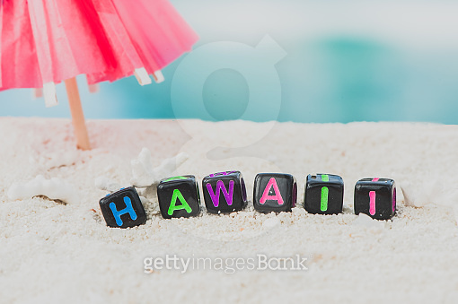 Word Hawaii is made of multicolored letters on snow-white sand against ...
