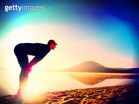 Film effect. Sportsman running at amazing summer sunset along coastline ...