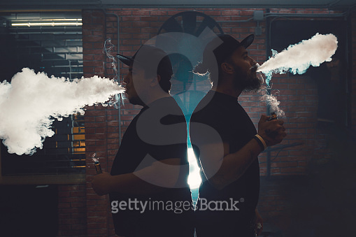 Two men vaping in an authentic room with brick walls 이미지 (814279798 ...