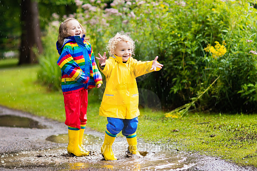 Kids play in rain and puddle in autumn (675010648) - 게티이미지뱅크