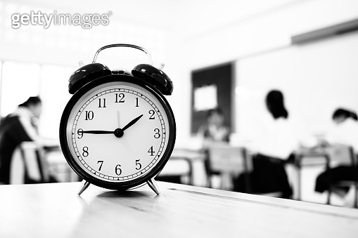 Alam clock located on wood teacher table in final exam room of ...