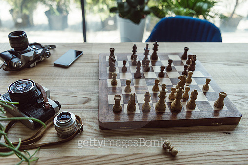 Creative workplace concept with old retro cameras, smartphone and chess ...
