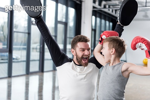 Excited young boy boxer with his coach at training (695499254) - 게티이미지뱅크