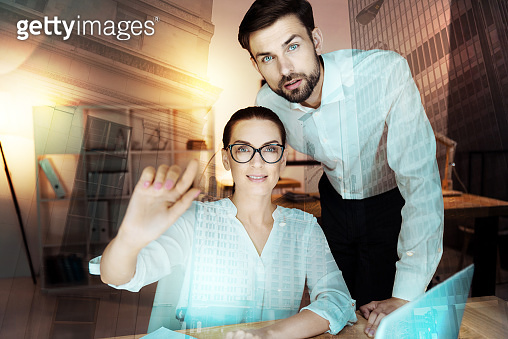 Handsome man watching his colleague touch interactive screen (896772162 ...