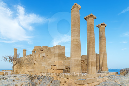 Ancient Greek acropolis. Front view of columns and walls. near the tree ...