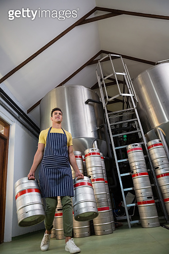 Full length of worker holding kegs at warehouse 이미지 (839187566) - 게티이미지뱅크