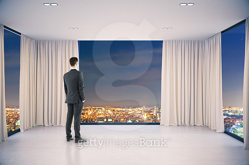 Man in room with city view 이미지 (628898772) - 게티이미지뱅크