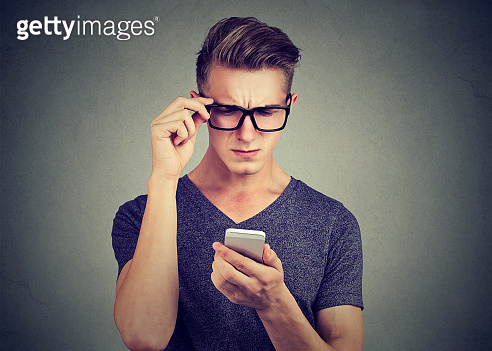 Closeup portrait of a man wearing glasses having trouble seeing cell ...