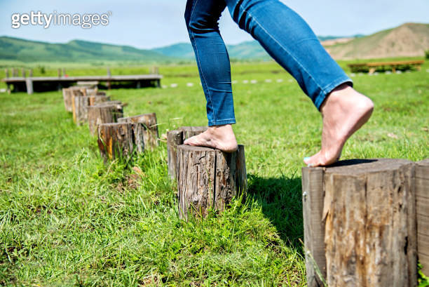 Woman walking on stepping tree stump 이미지 (660643470) - 게티이미지뱅크