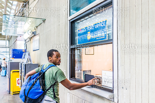 Inside Union Station in capital city with young man at bus ticket booth ...