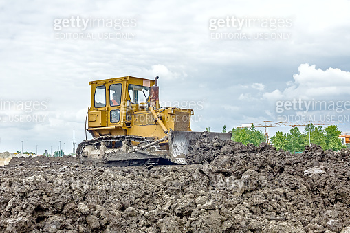 Heavy earthmover construction machine is moving earth at building site ...