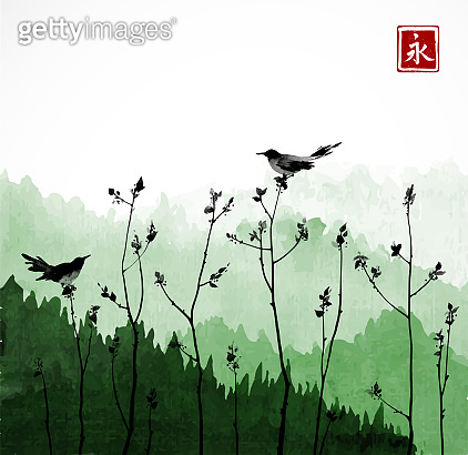 Two black birds on trees branches and mountains with forest trees ...