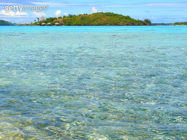Motu island with rustic thatched roof palapas and Polynesian Tropical ...