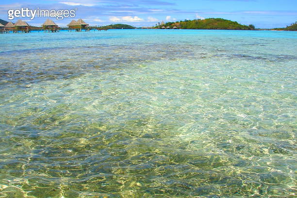 Motu island with rustic thatched roof palapas and Polynesian Tropical ...