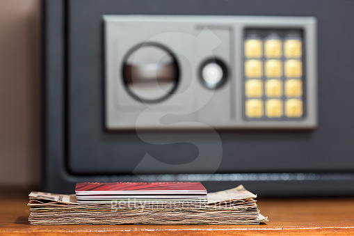 Closeup on banknotes and credit cards in front of safety box with ...