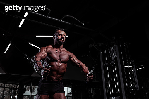 Sportsman in gym. Muscular athletic man doing chest exercises using ...