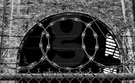 Circle shapes of barbed wire with brick warehouse background repeating ...