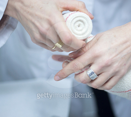 Doctor applying a plaster cast and bandages to patient forearm and ...
