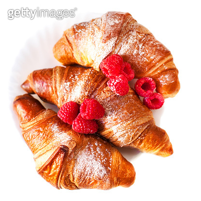 Fresh golden croissants with raspberries close up isolated on white ...