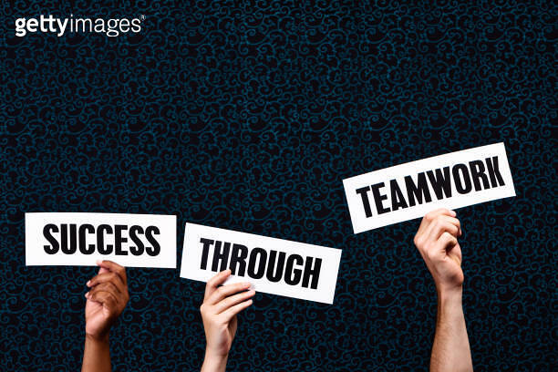Hand-held signs say "Success through teamwork" (832032762) - 게티이미지뱅크