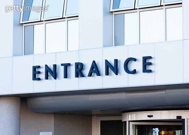 Entrance sign above modern building's revolving door (831593920) - 게티이미지뱅크