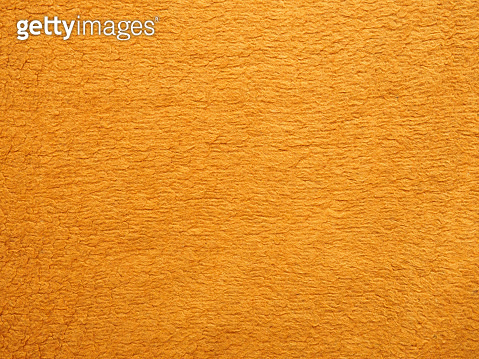 A full page of orange faux fur, fluffy material. View of top on ...