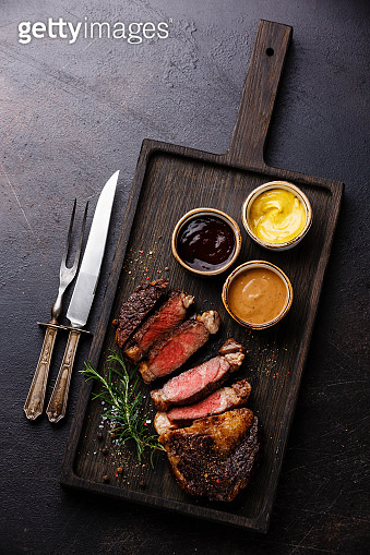 Sliced grilled Rib eye steak and three different sauces (854385572 ...