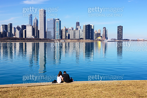 Couple sitting in front of Lake Michigan, Chicago skyline 이미지 ...