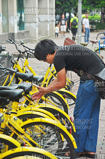 People use smartphone to scan the QR code on a shared bike to unlock it ...