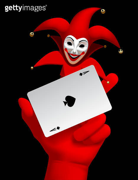 Human hand with a smiled Joker head and ace of Spades playing card ...