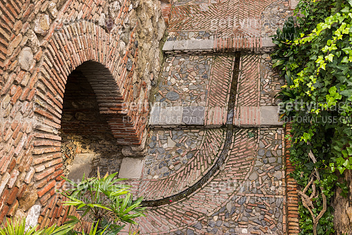 Medieval stone arches and walkway by the walls and towers of an ancient ...