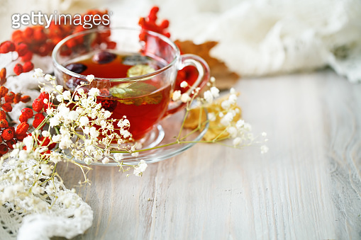A Cup of tea and Rowan berries on a wooden table. Autumn still-life 이미지 ...