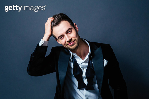 Portrait of a young handsome man in a suit, smiling, bow tie and top ...