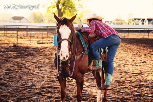 Ten Year Old Girl Climbing onto her horse in a corral 이미지 (1059781514 ...
