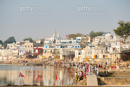 Hindu devotees pilgrims bathing in sacred Pushkar lake (Sagar) on ghats ...