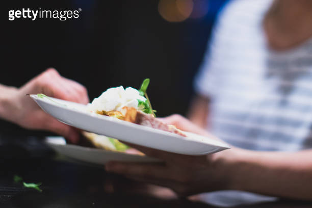 Waitress grabbing many plates in a restaurant kitchen. Food industry in ...