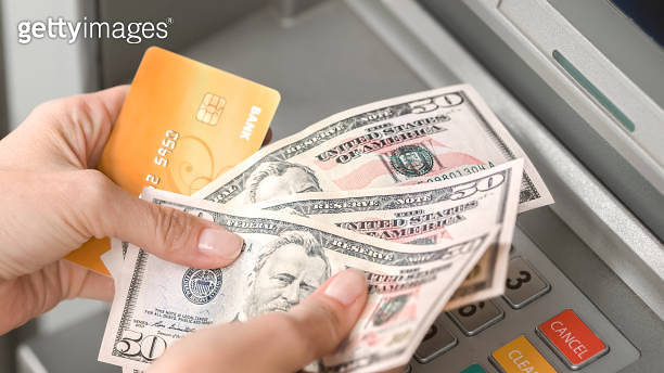 Woman taking money out of cash dispenser at ATM, counting it (913326882 ...