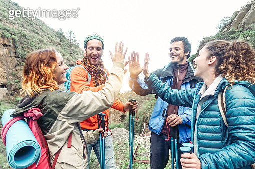 Group of friends stacking hands while doing trekking excursion on ...