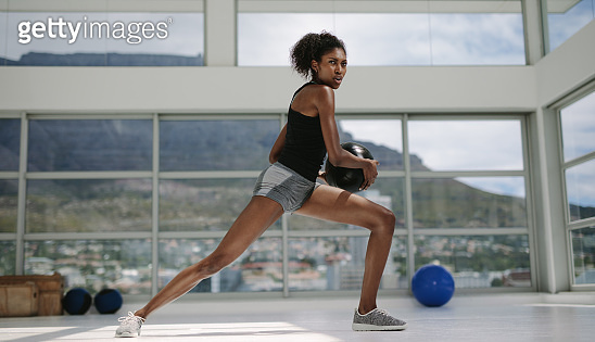 African girl doing stretching exercise with medicine ball 이미지 ...