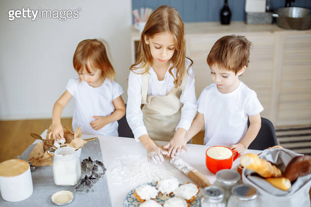 Three little chefs enjoying in the kitchen making big mess. Kids making ...