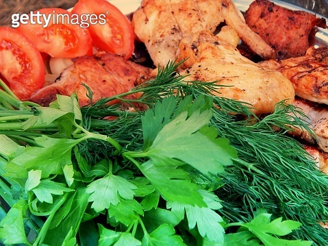 Barbecue still life. Chicken meat with greens and tomato slices close ...