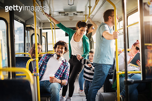 Young mother and her son are trying not to fall in a bus full of people ...
