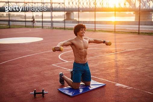 Young determinative fit man working out early in the morning. Training ...