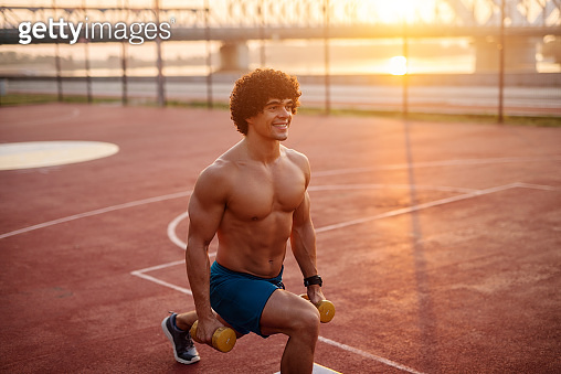 Young determinative fit man working out early in the morning. Training ...