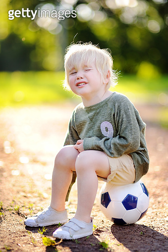 Little boy crying after fall during soccer/football game on summer day ...